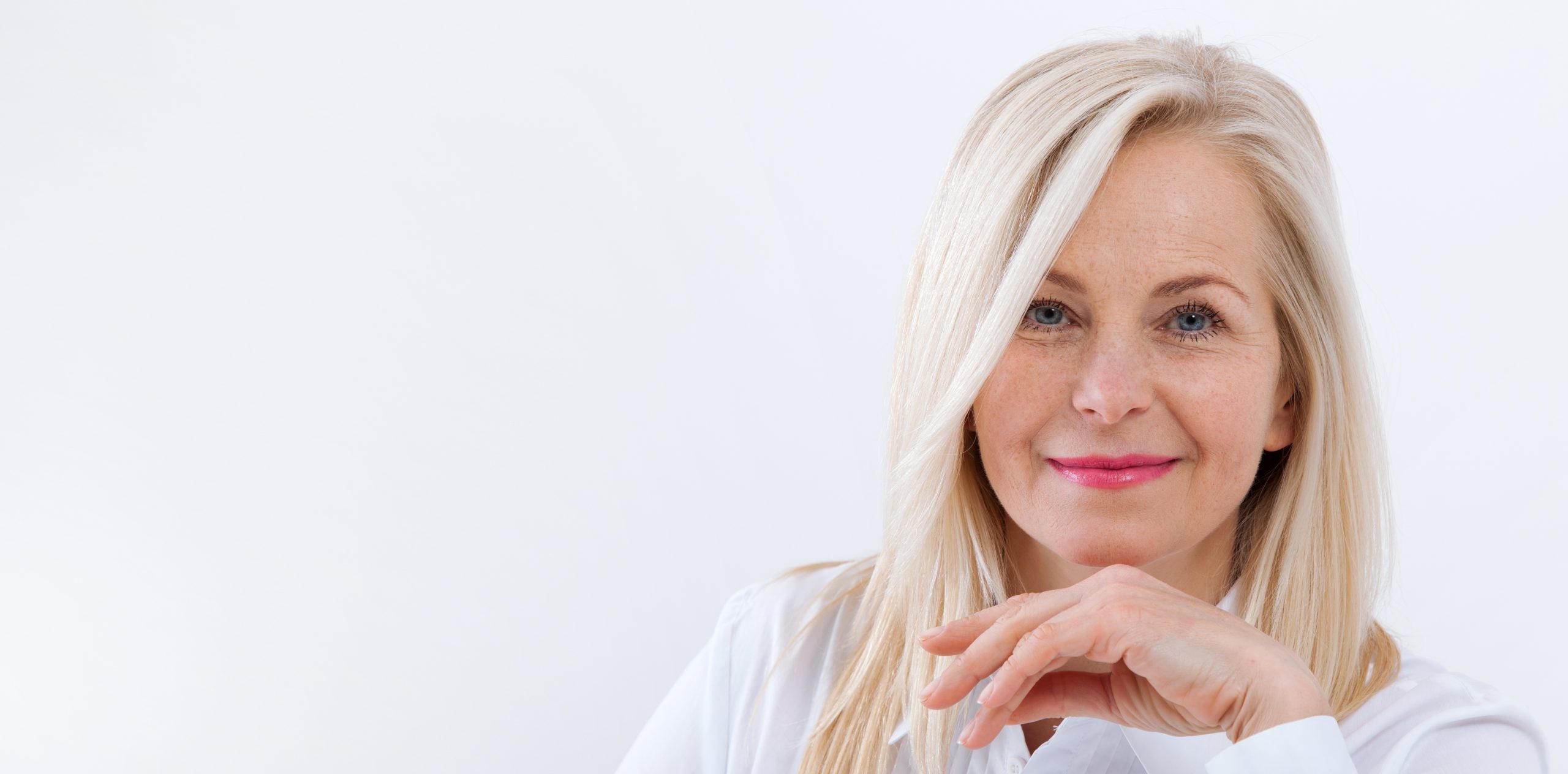 Lovely Middle Aged Blond Woman With A Beaming Smile Sitting At Office